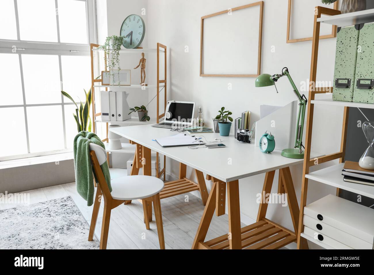 Interior of light office with workplace and shelving units Stock Photo ...