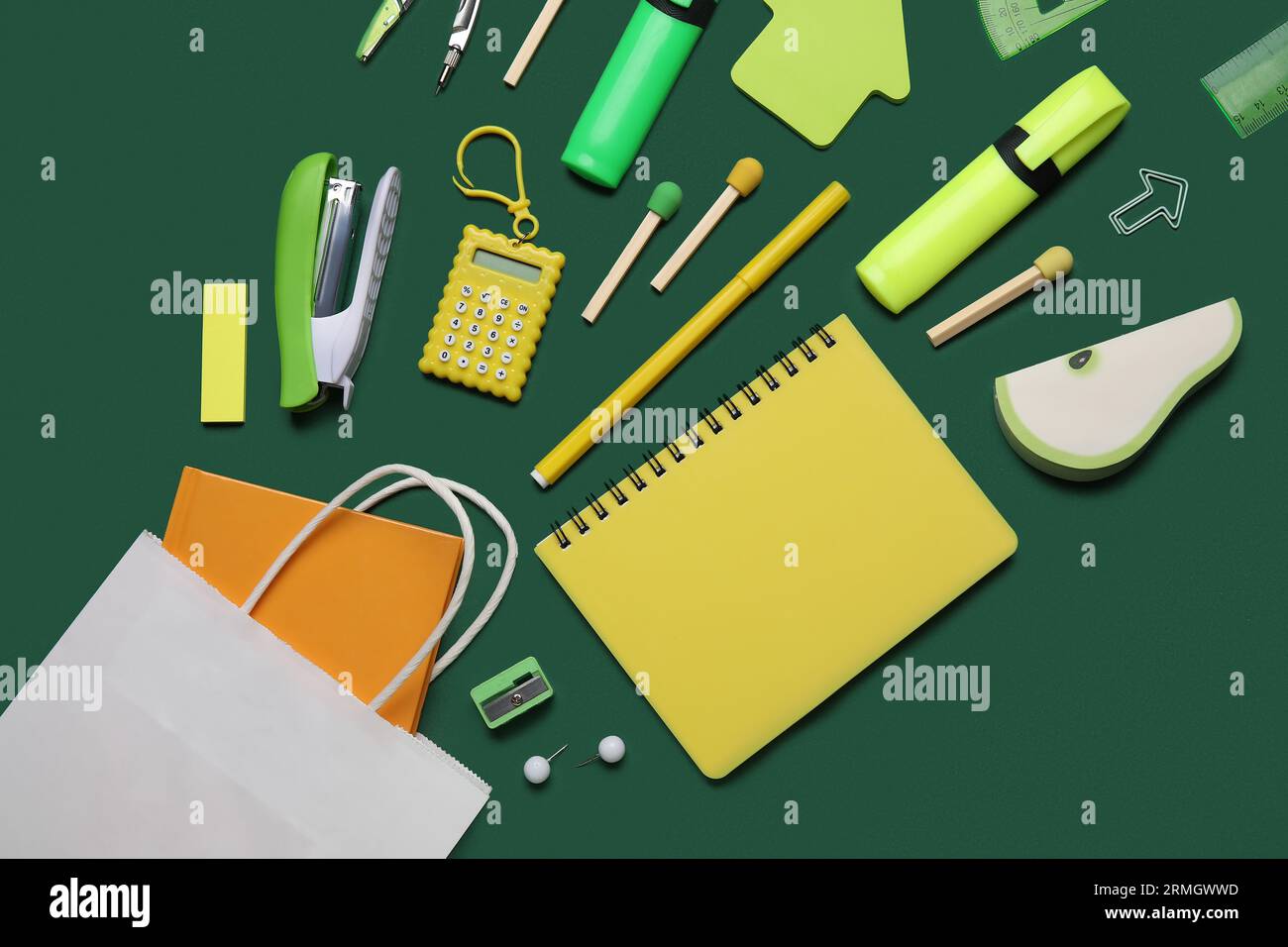 Shopping bag with different school stationery on green background Stock ...