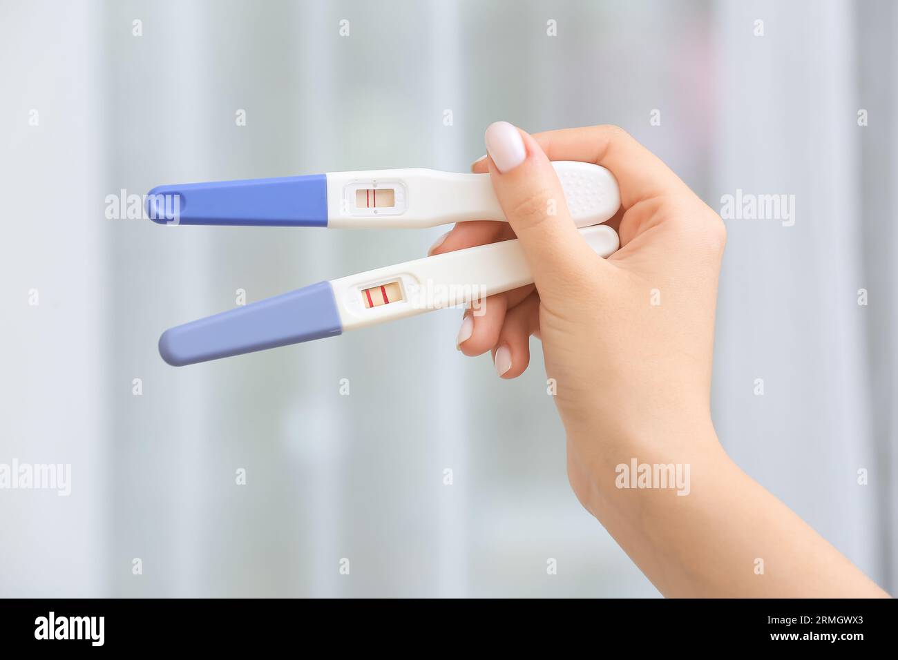 Female hand with positive pregnancy tests against window, closeup Stock ...