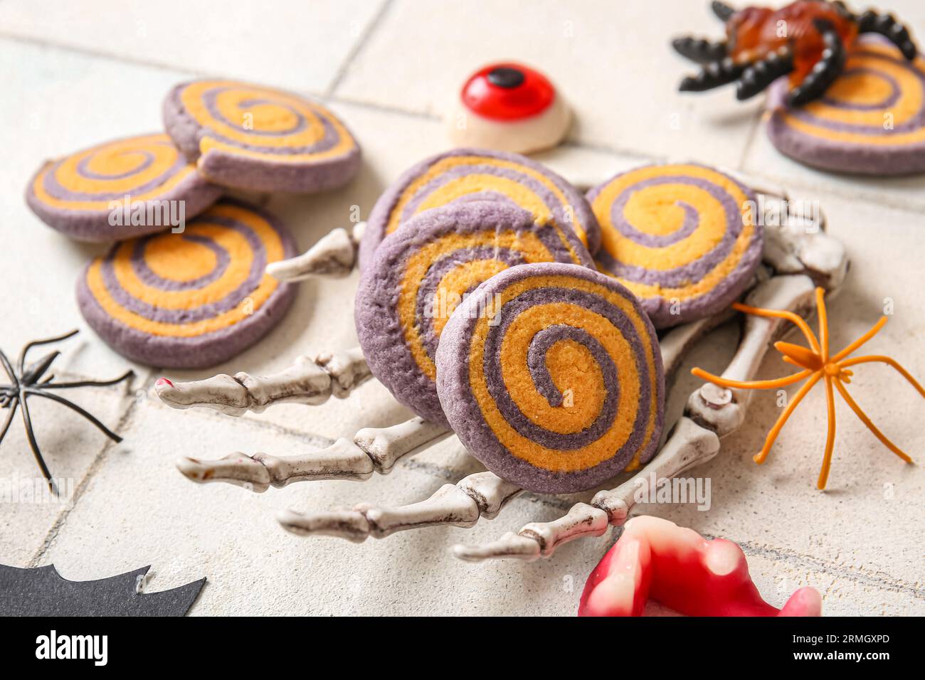 Skeleton hand with tasty cookies and Halloween decorations on white ...