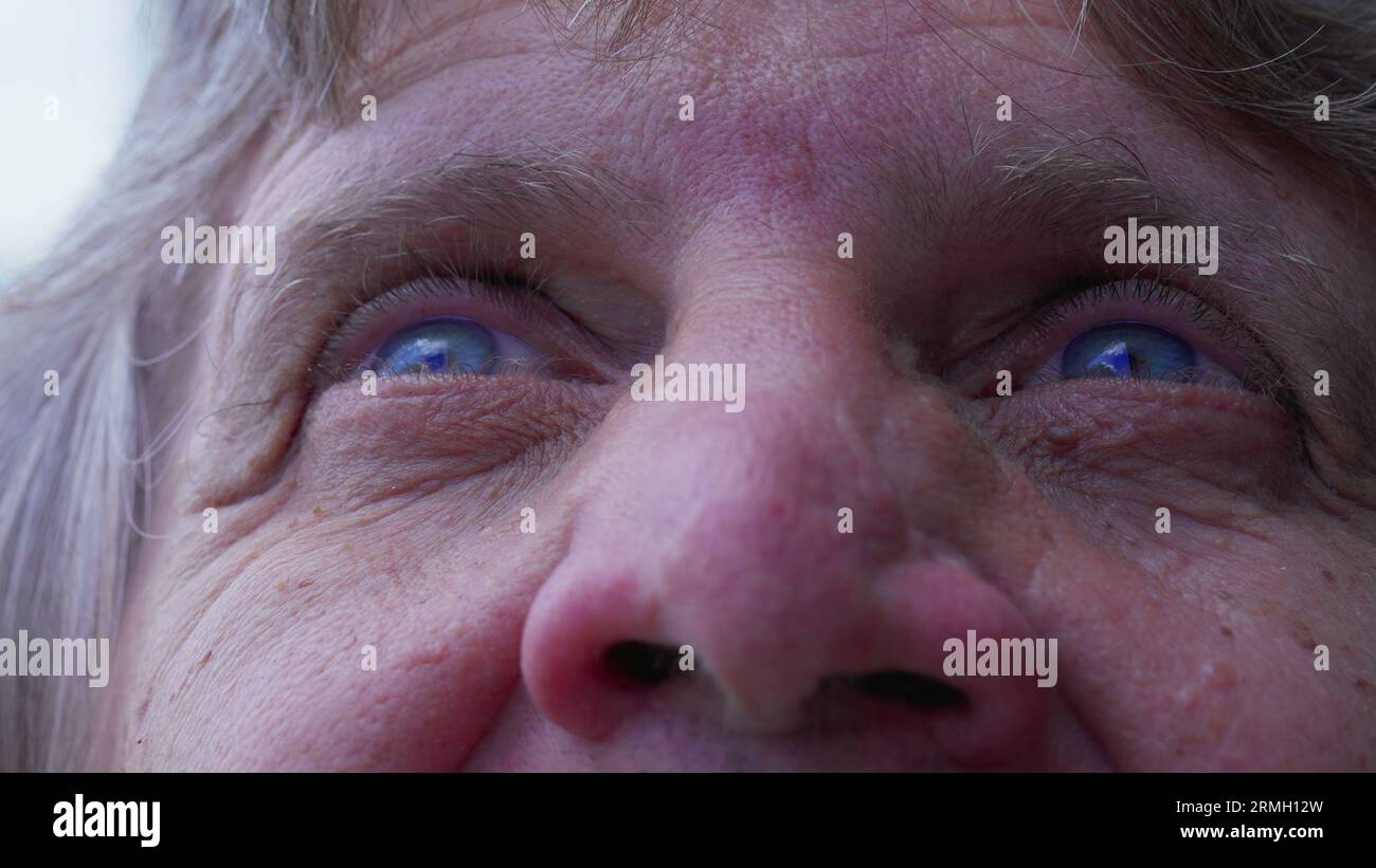 Hopeful senior man with blue eyes looking up at sky with FAITH and ...