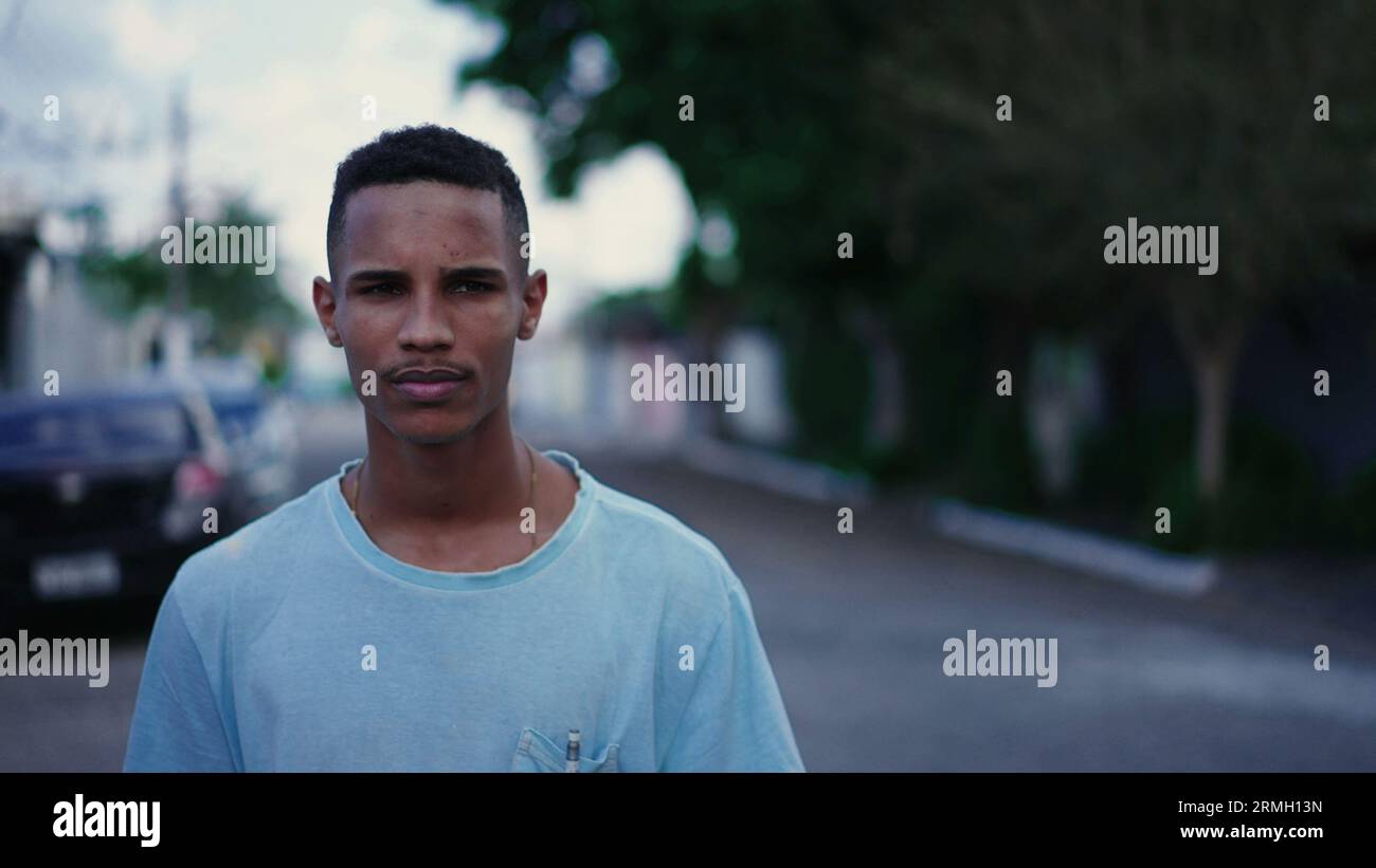 One confident young black man walking forward in street. Close-up face ...