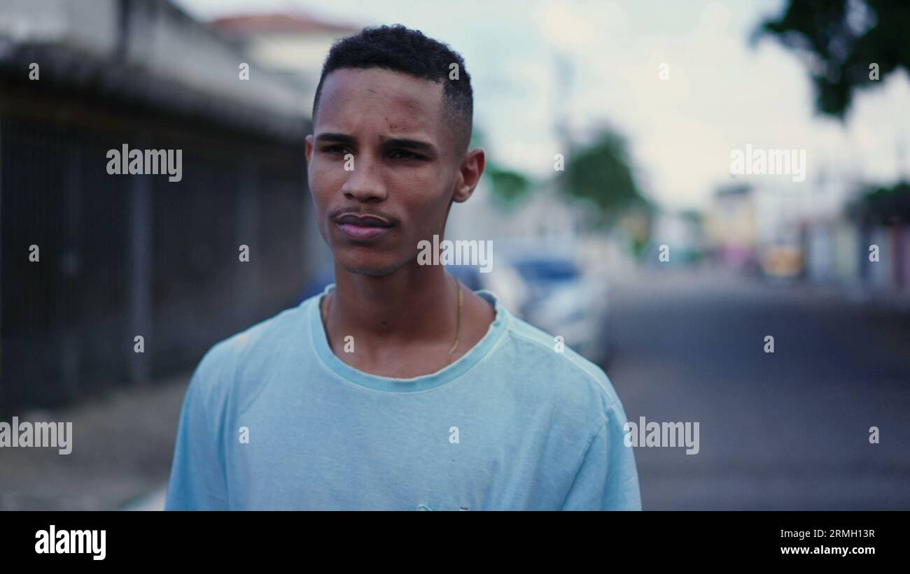 One confident young black man walking forward in street. Close-up face ...
