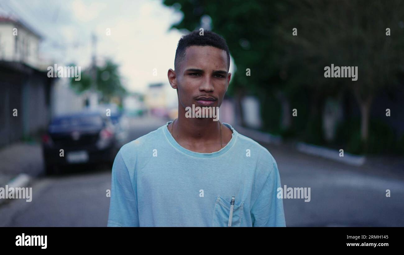 One confident young black man walking forward in street. Close-up face ...