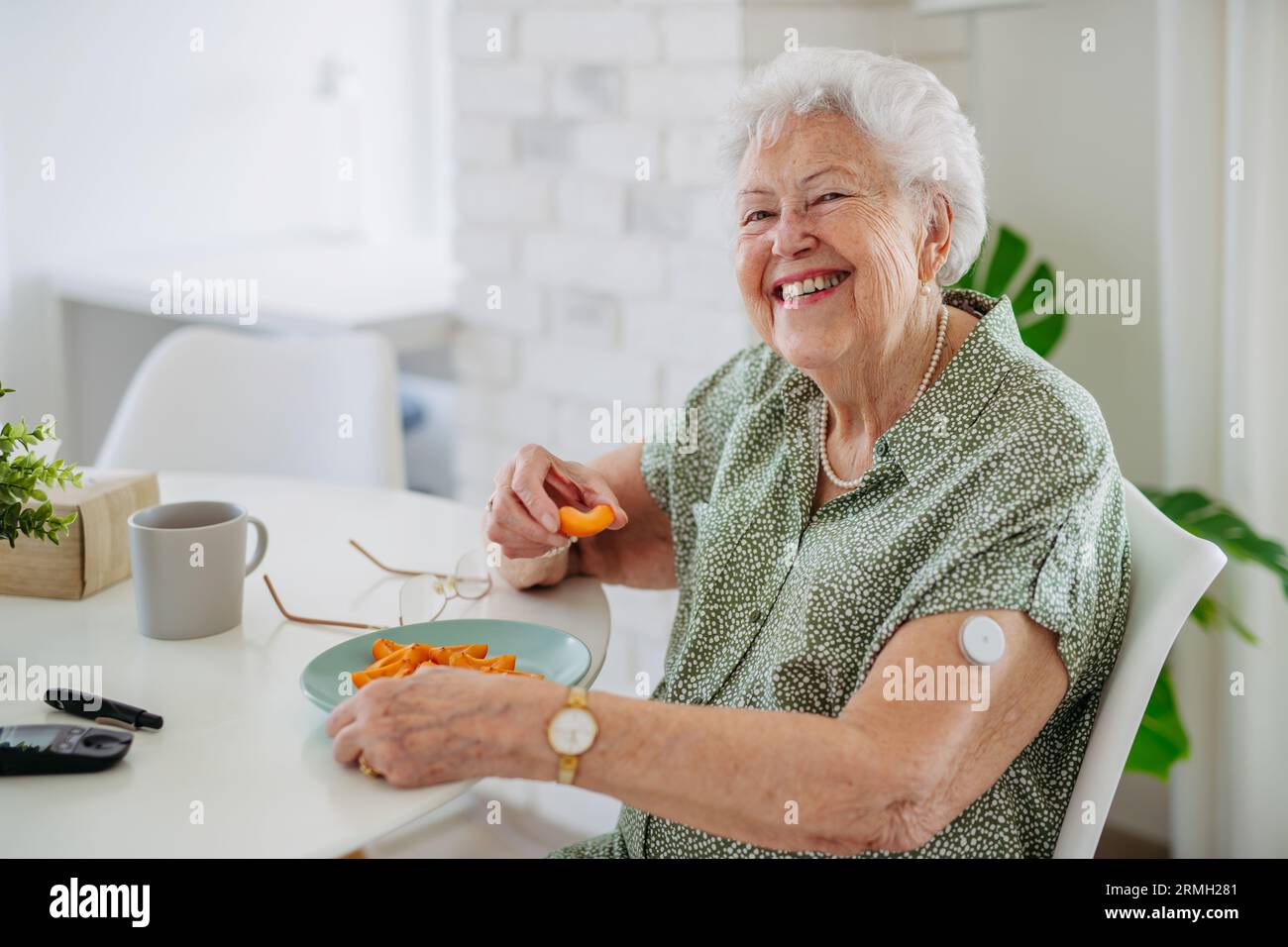 Diabetic senior patient using continuous glucose monitor to check blood ...
