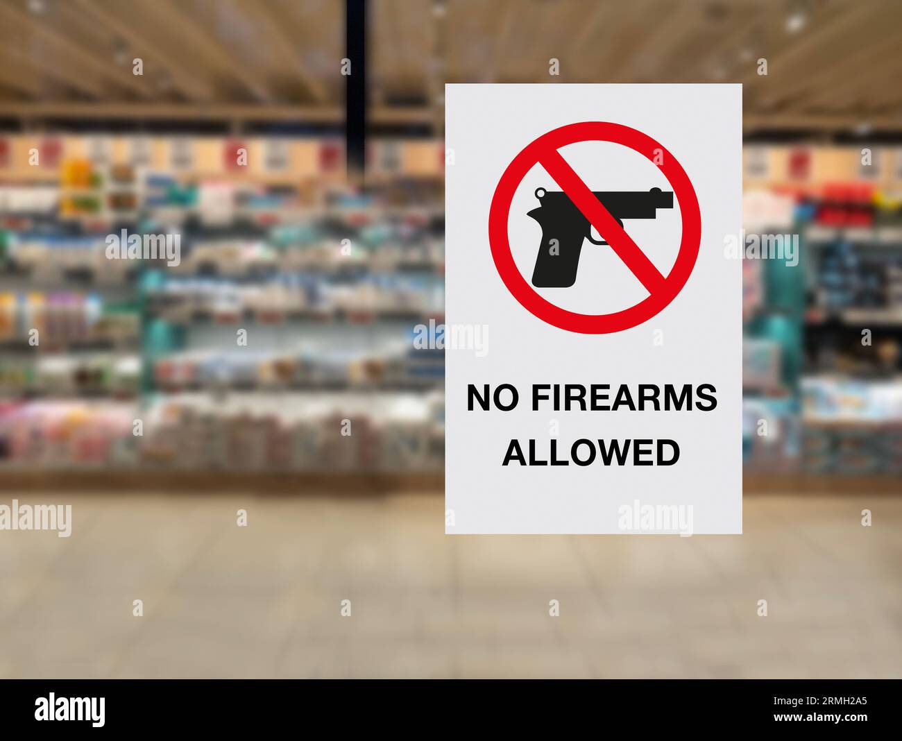 No firearms allowed sign posted on a shop glass window. Concept image ...