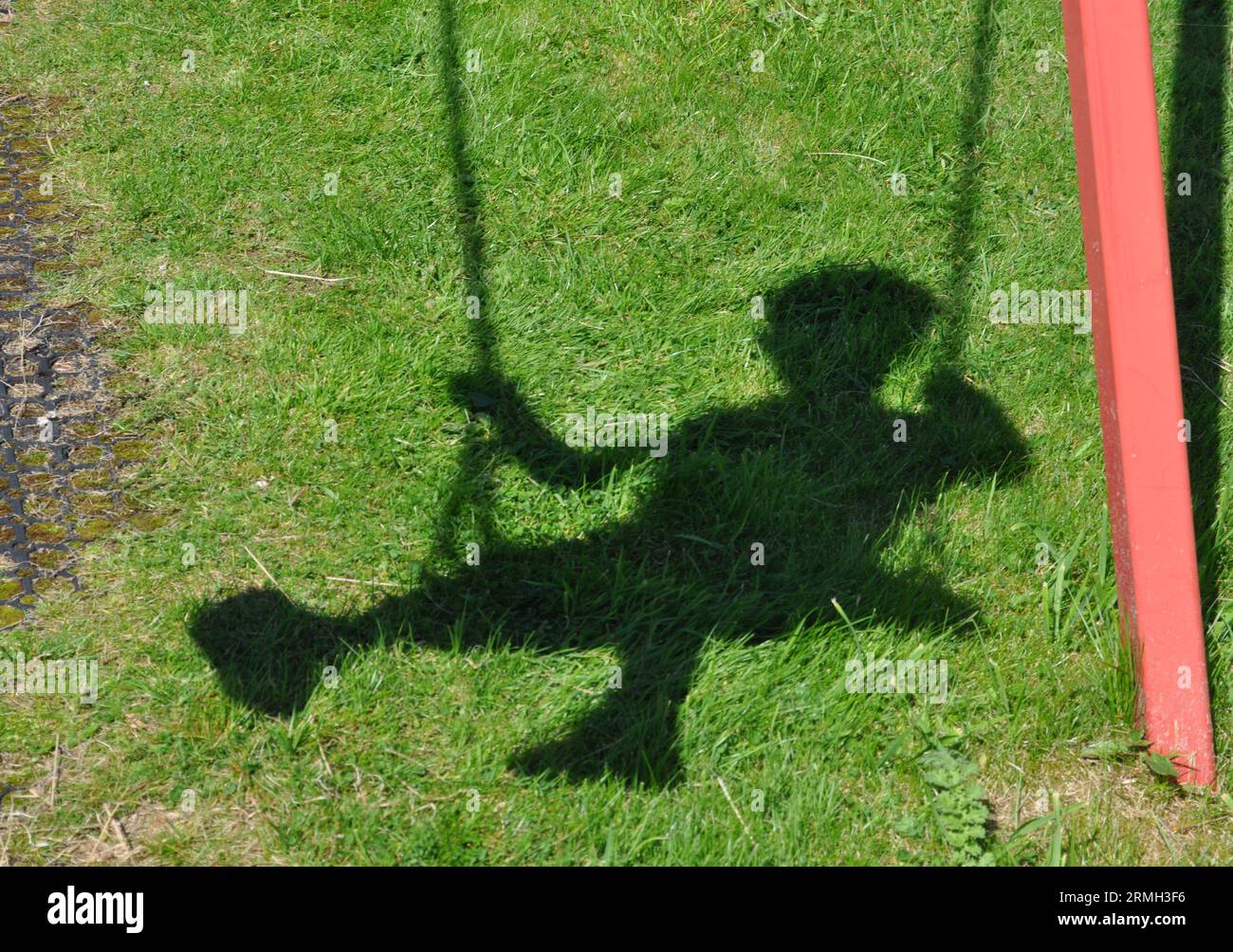 Shadow of a young child swinging on a swing Stock Photo - Alamy