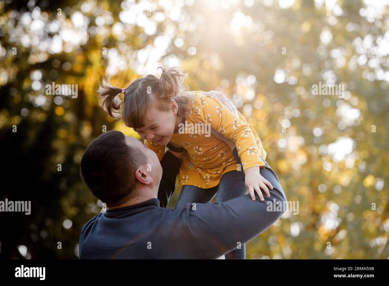Happy fathers day. Joyful dad throws up his little smiling daughter at ...