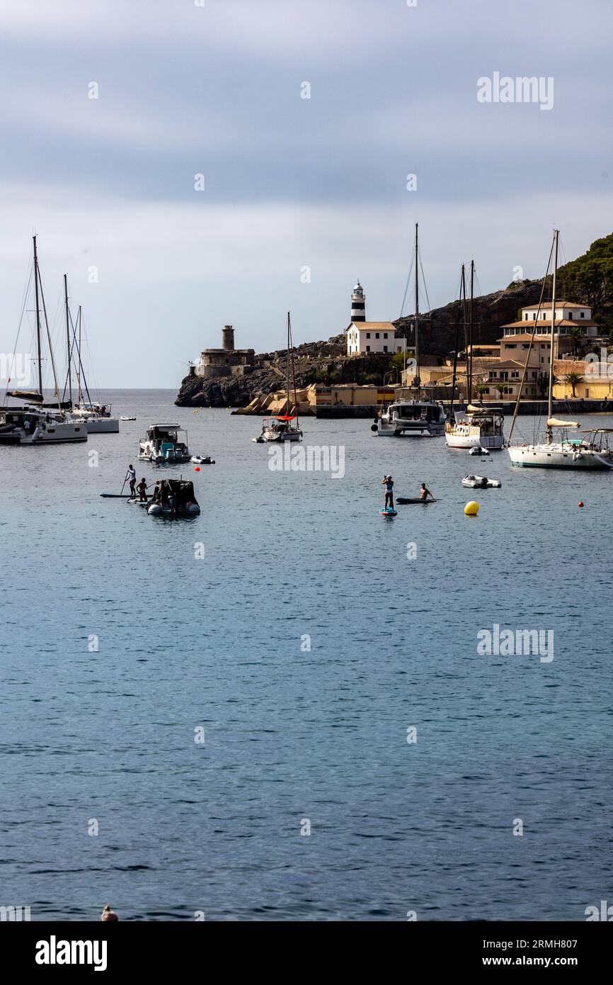 Boats in a port with a lighthouse in the background Stock Photo - Alamy