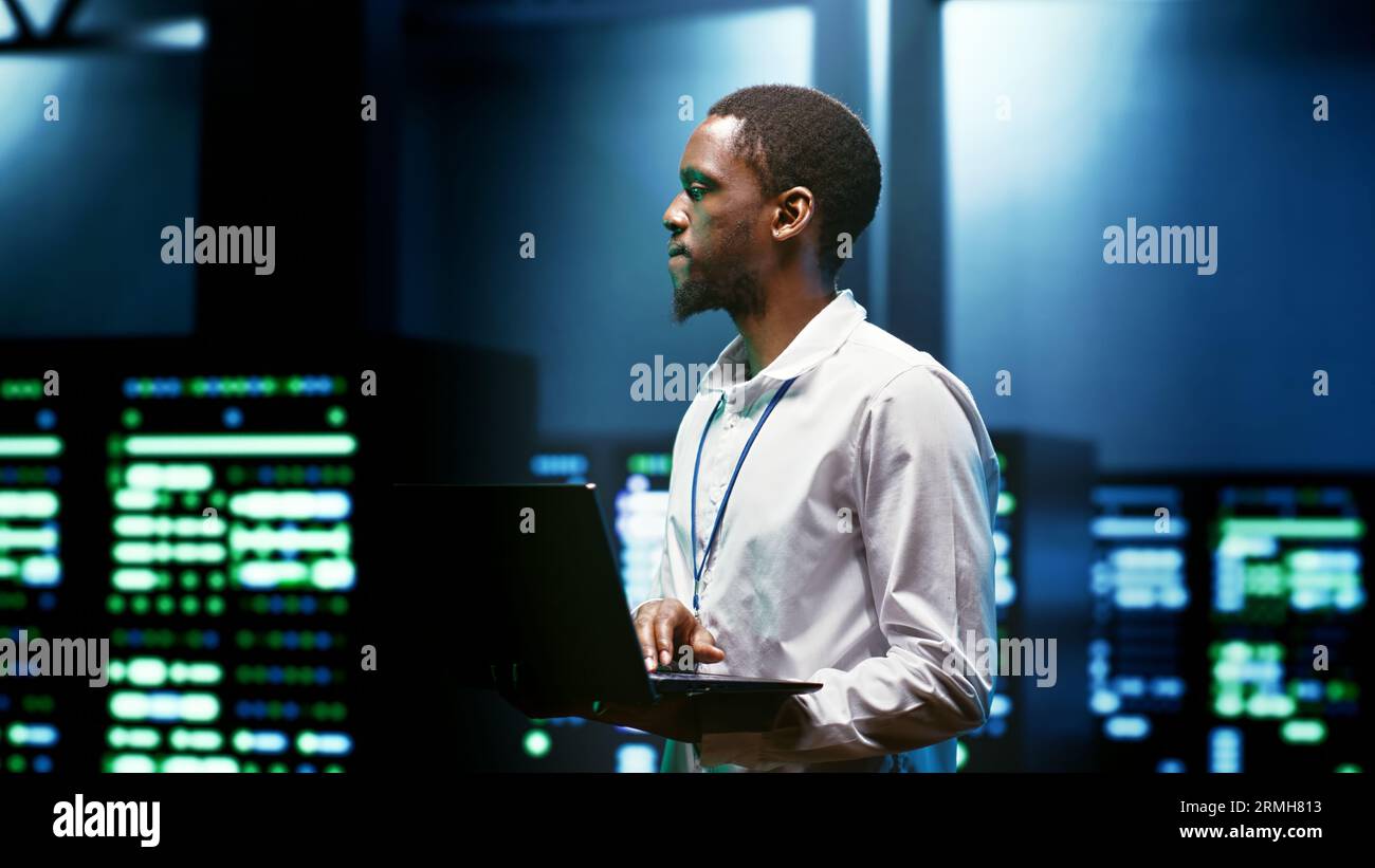 IT programmer setting up high tech facility advanced firewalls, intrusion detection systems and ...