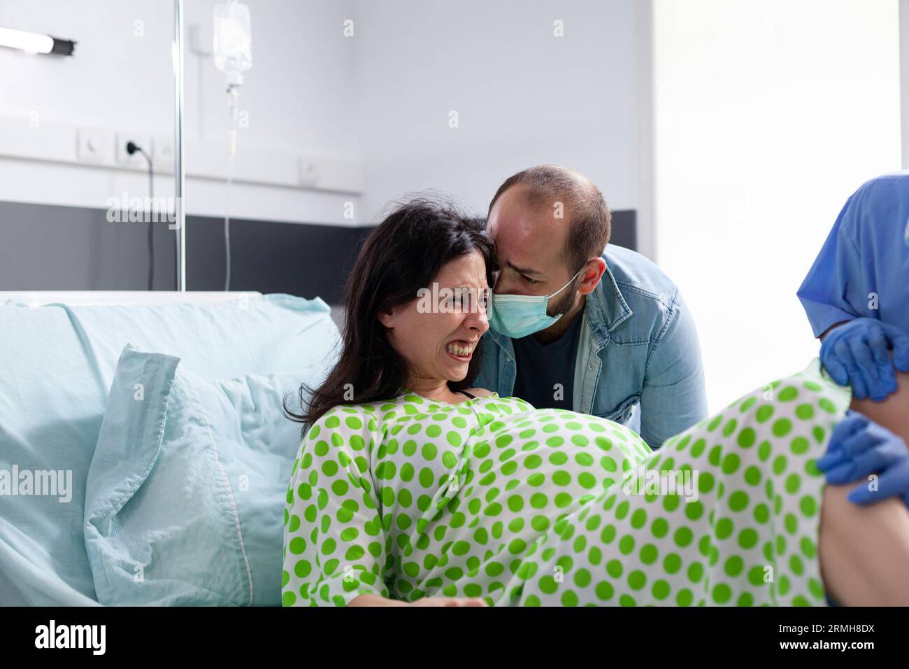 Diverse medical team helping woman with pregnancy to delivery baby in ...