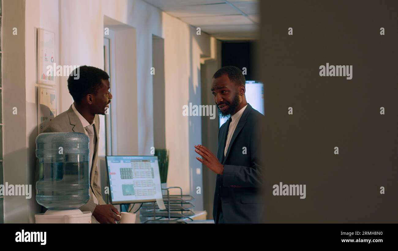 Happy coworkers discussing holiday plans during nightshift break in ...