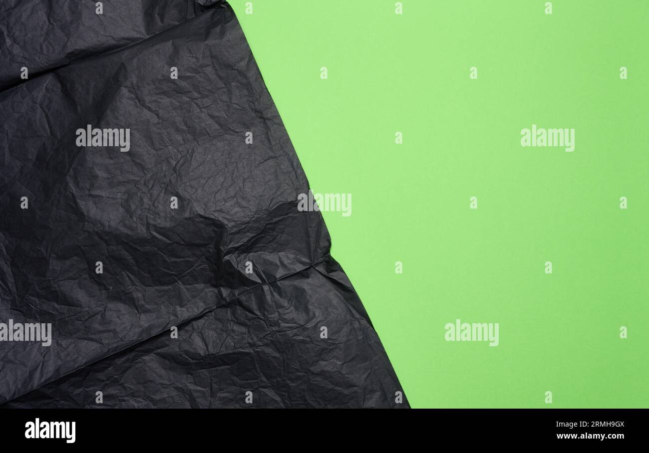 Crumpled sheet of black parchment paper, green background Stock Photo ...