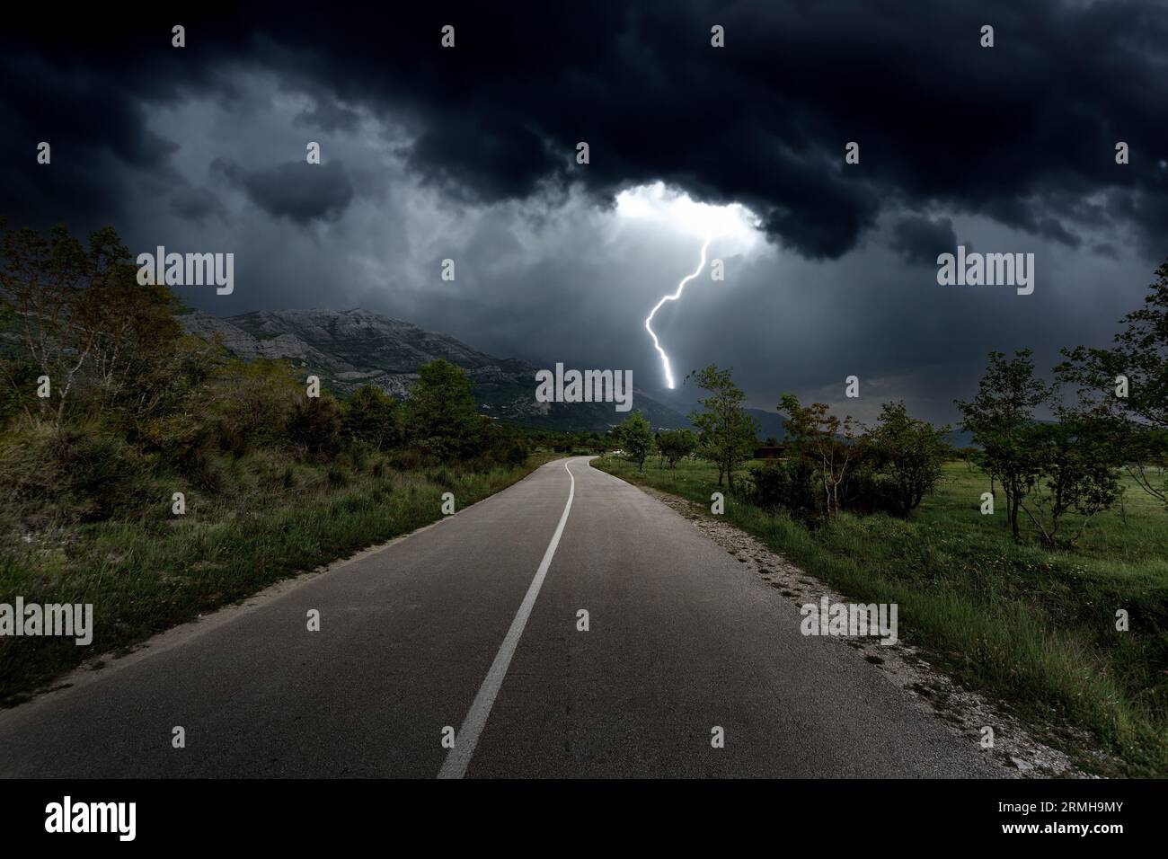 Storm with rain and lightning over mountains road Stock Photo - Alamy