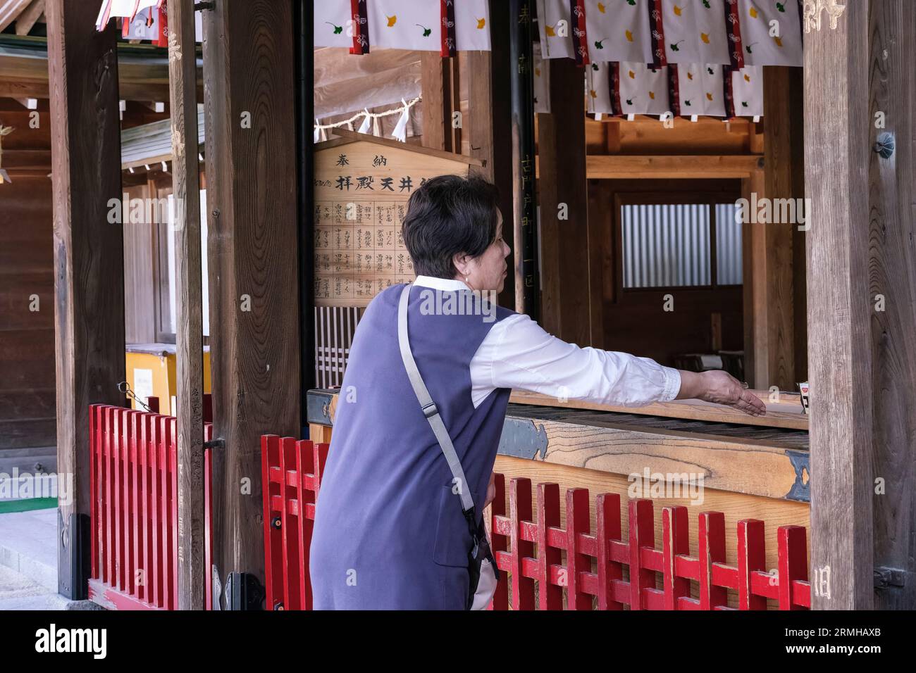 Japan, Kyushu, Fukuoka, Hakata. Kushida Shinto Shrine. Woman Placing ...