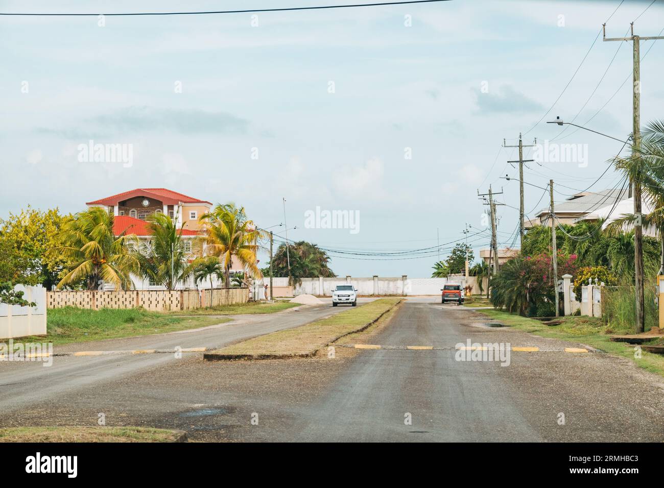 a wide, double lane residential street in Belize City, Belize Stock ...