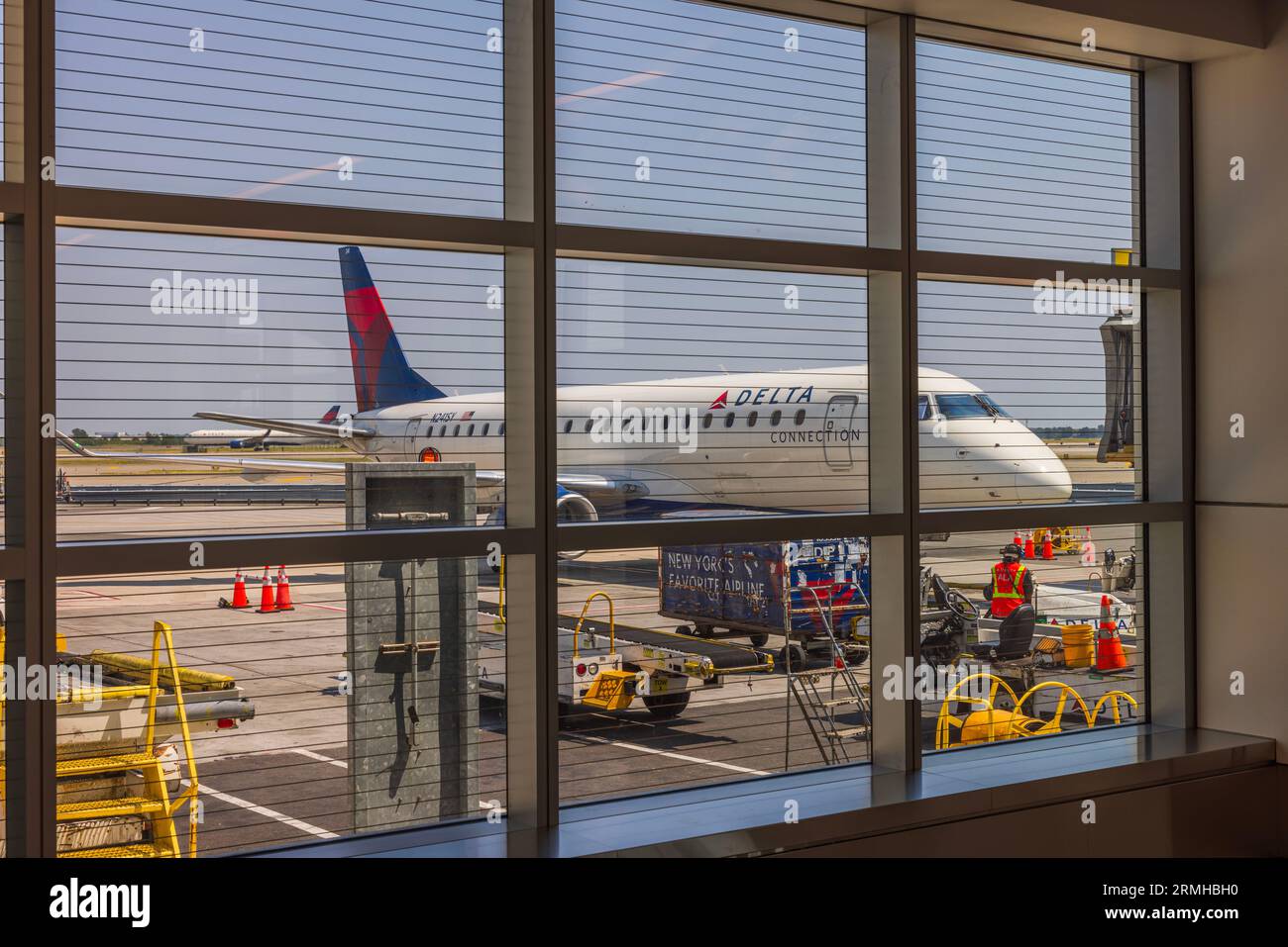 View of parked Delta aircraft from inside of airport through window ...