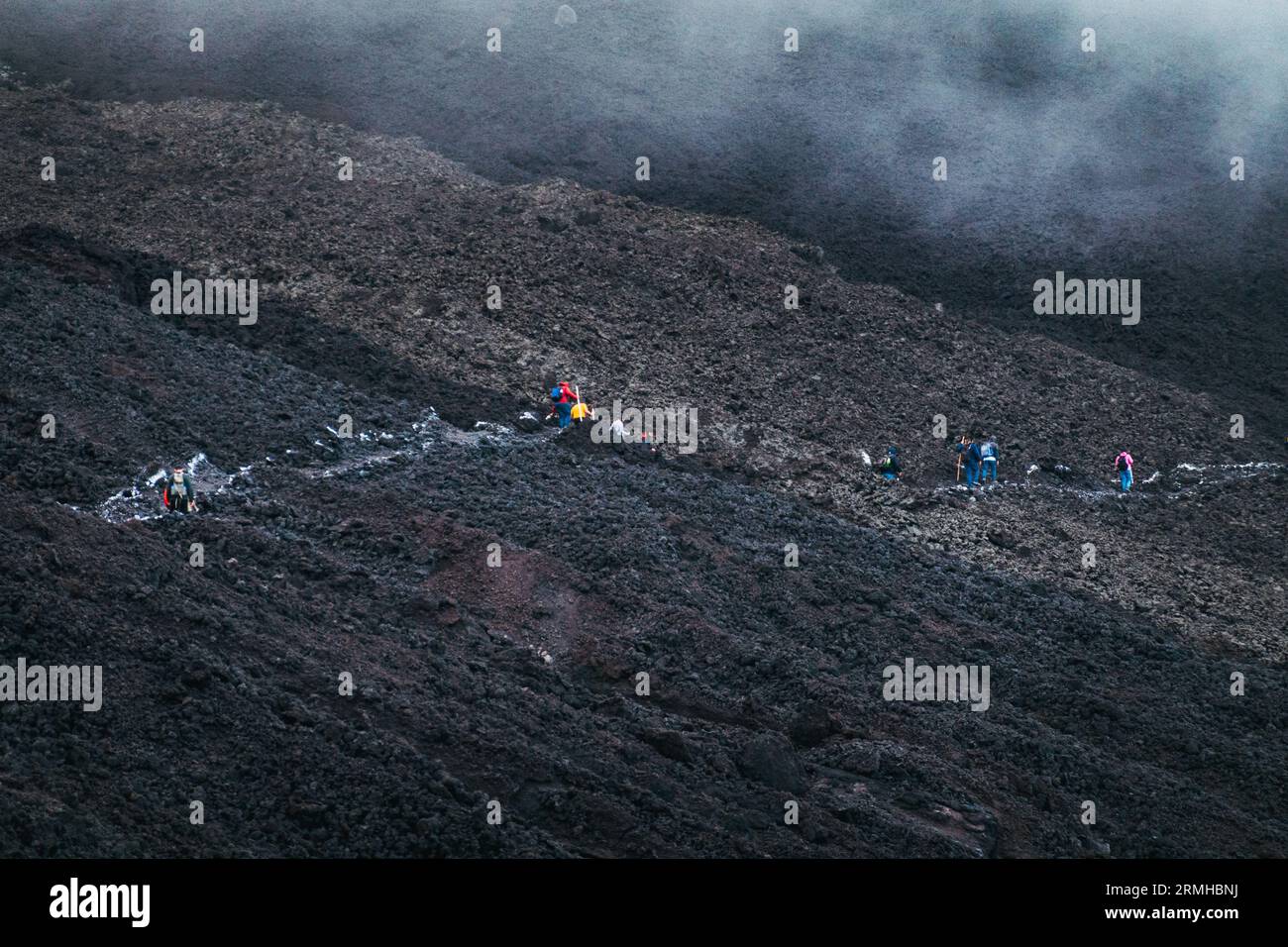 Hikers walk across the hot, steaming volcanic slopes of the Pacaya ...