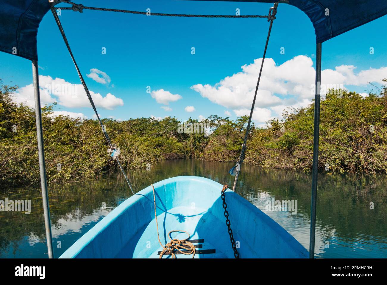 a boat navigates the Arroyo El Pucté river at Crater Azul (Blue Crater ...