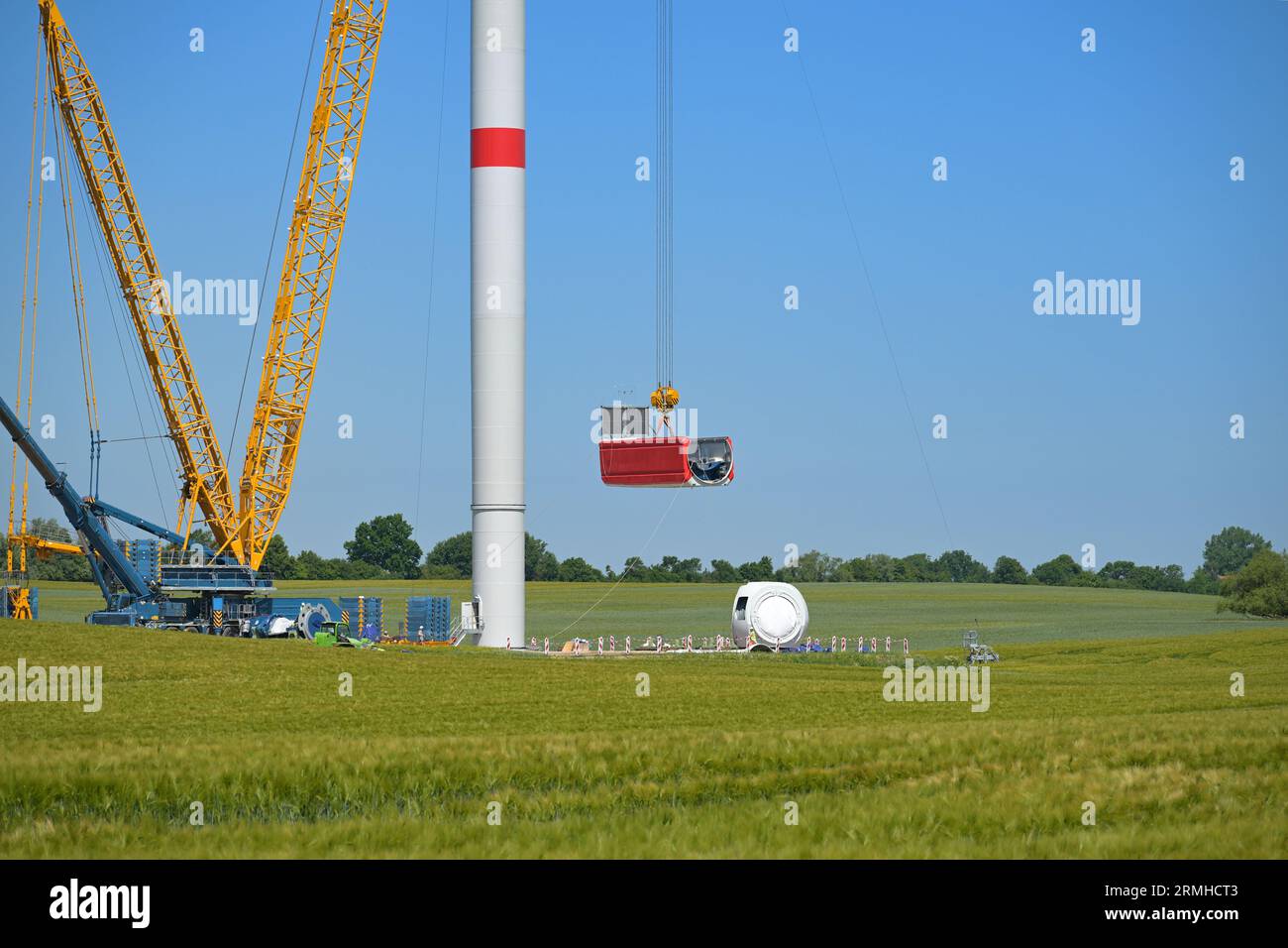 Construction site of a wind turbine, crane lifting the nacelle to ...
