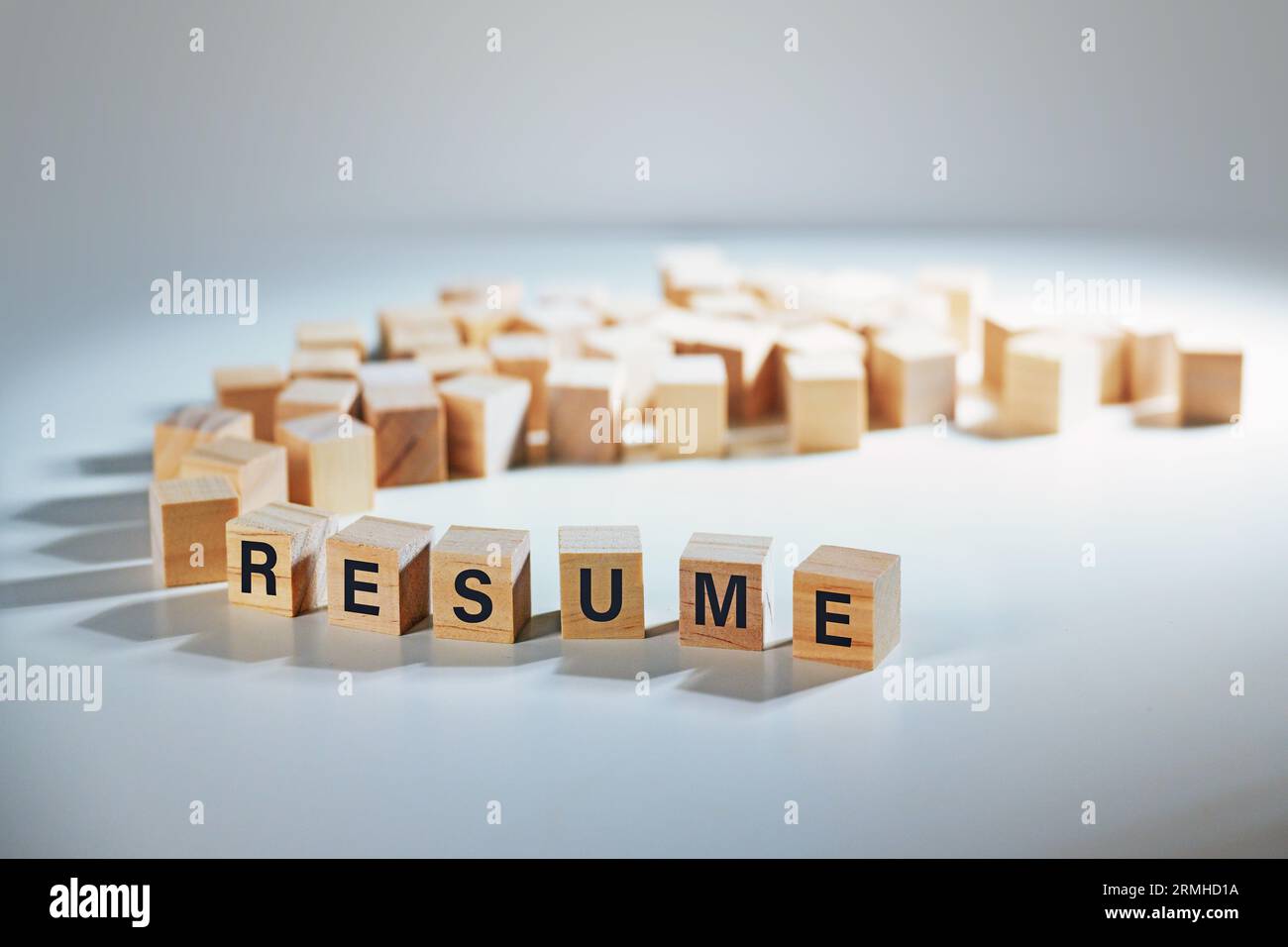 Word RESUME written on wooden cubes, many blurred cubes behind as a ...
