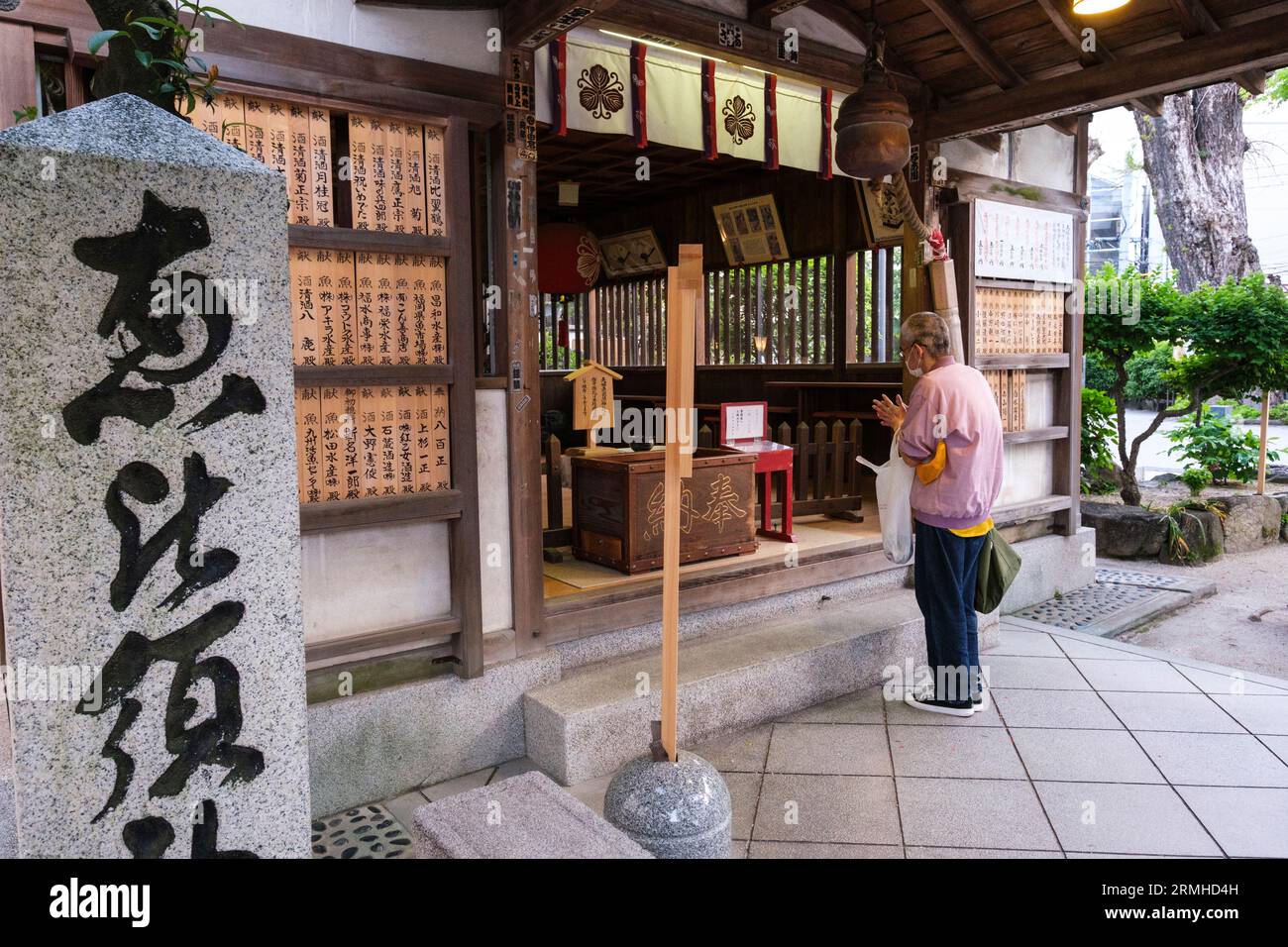 Japan, Fukuoka. Kushida Shinto Shrine. Worshipper Praying before a ...