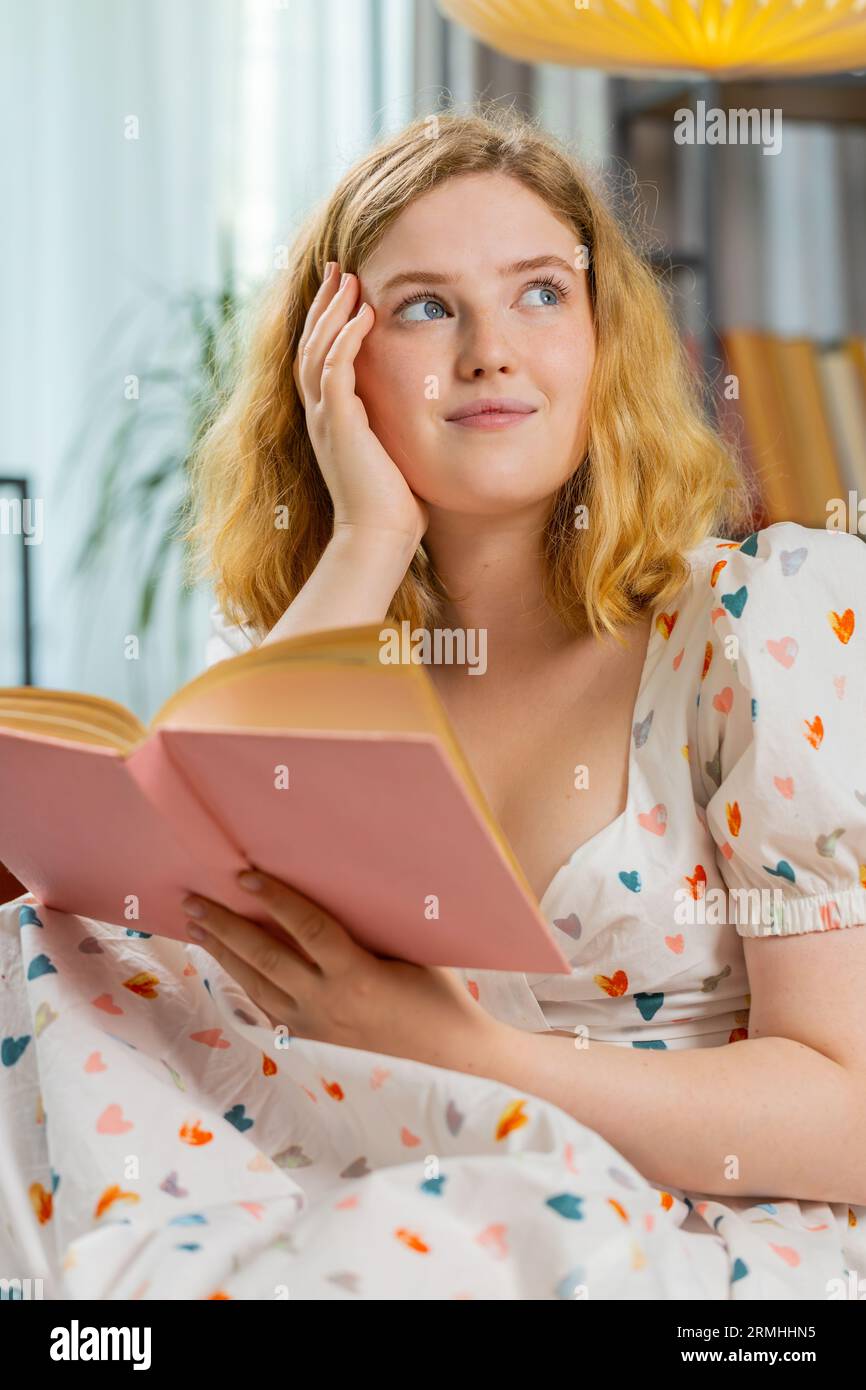 Happy red hair woman relaxing reading interesting book, turning pages ...