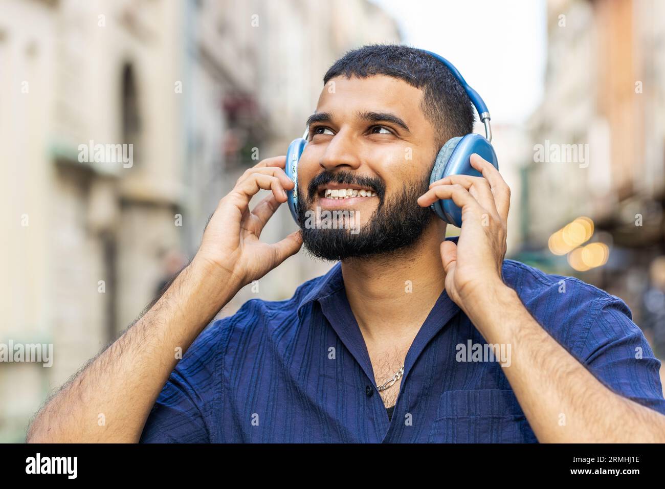 Joyful relaxed overjoyed bearded indian man in wireless headphones ...