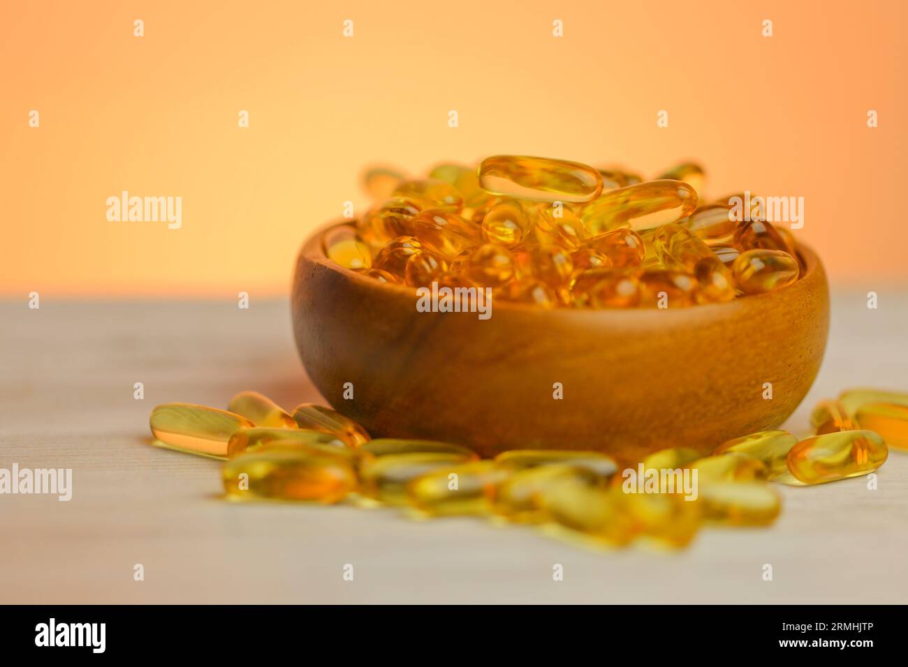 omega fatty acids oil capsules in a wooden cup .Fish oil jelly capsules ...