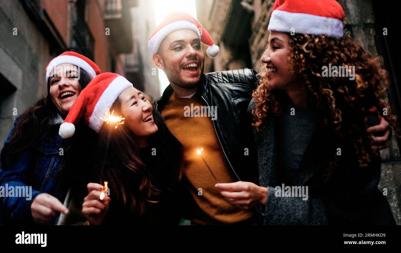 Happy diverse friends celebrate Christmas party with sparkler fireworks ...