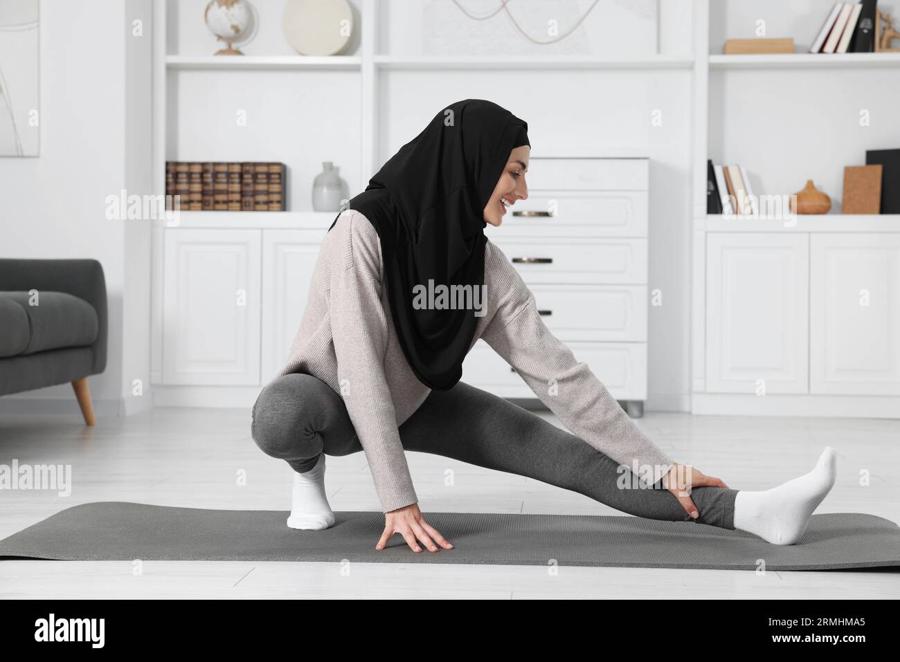 Muslim woman in hijab stretching on fitness mat at home Stock Photo - Alamy