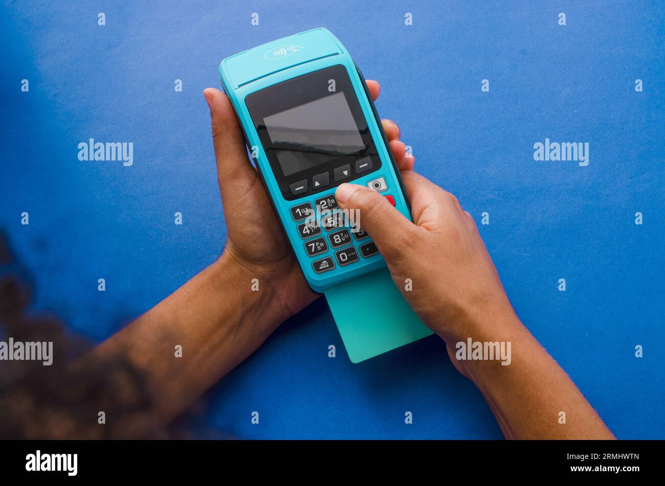 Closeup of hands holding a modern credit card payment device ...