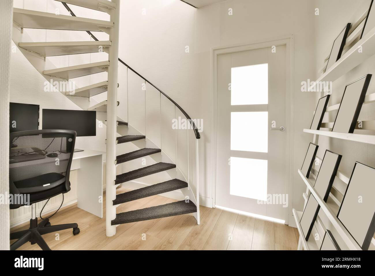 a room with some stairs and a computer on the desk next to an open door ...