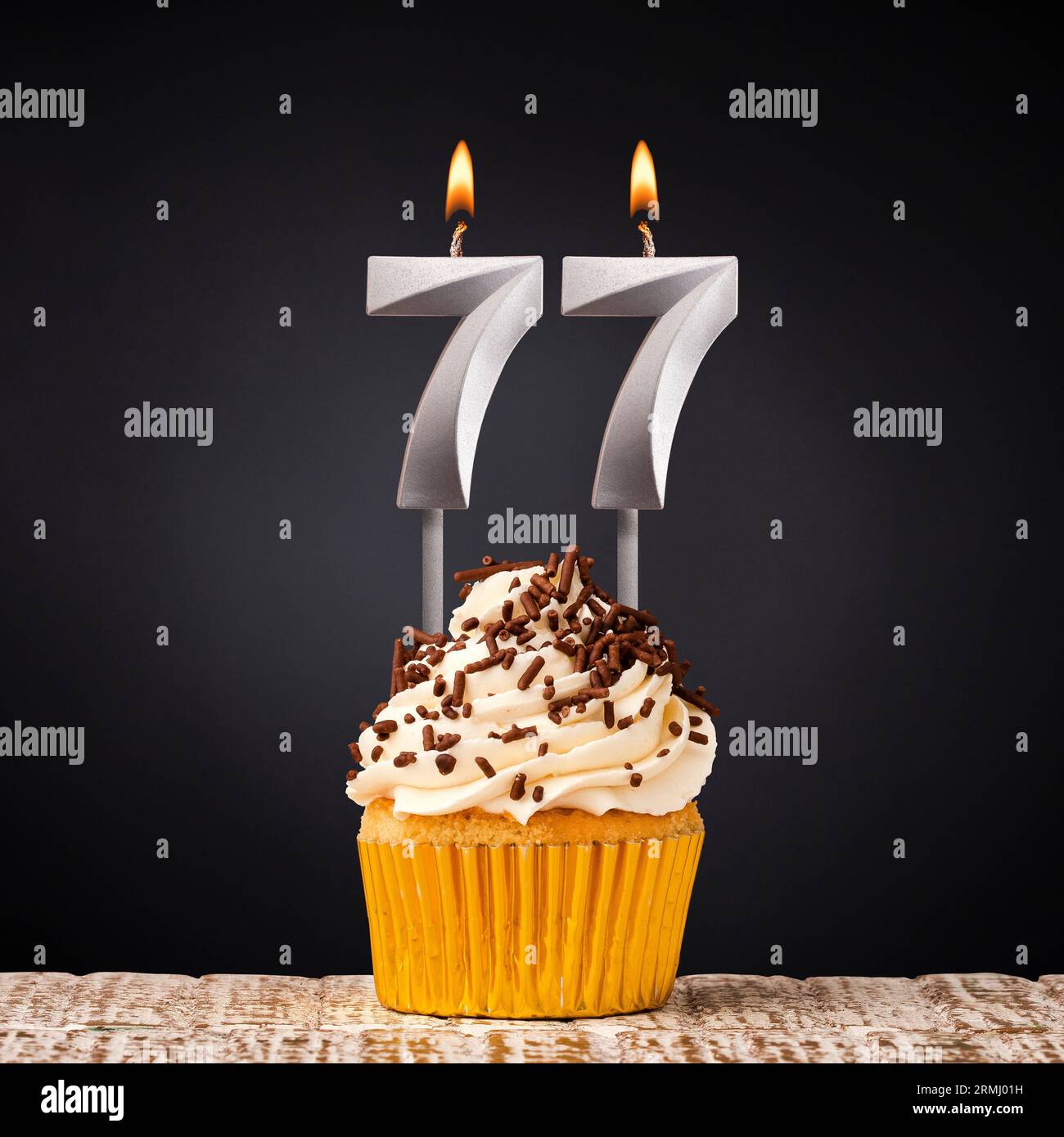 Birthday candle number 77 - Anniversary cupcake on black background ...