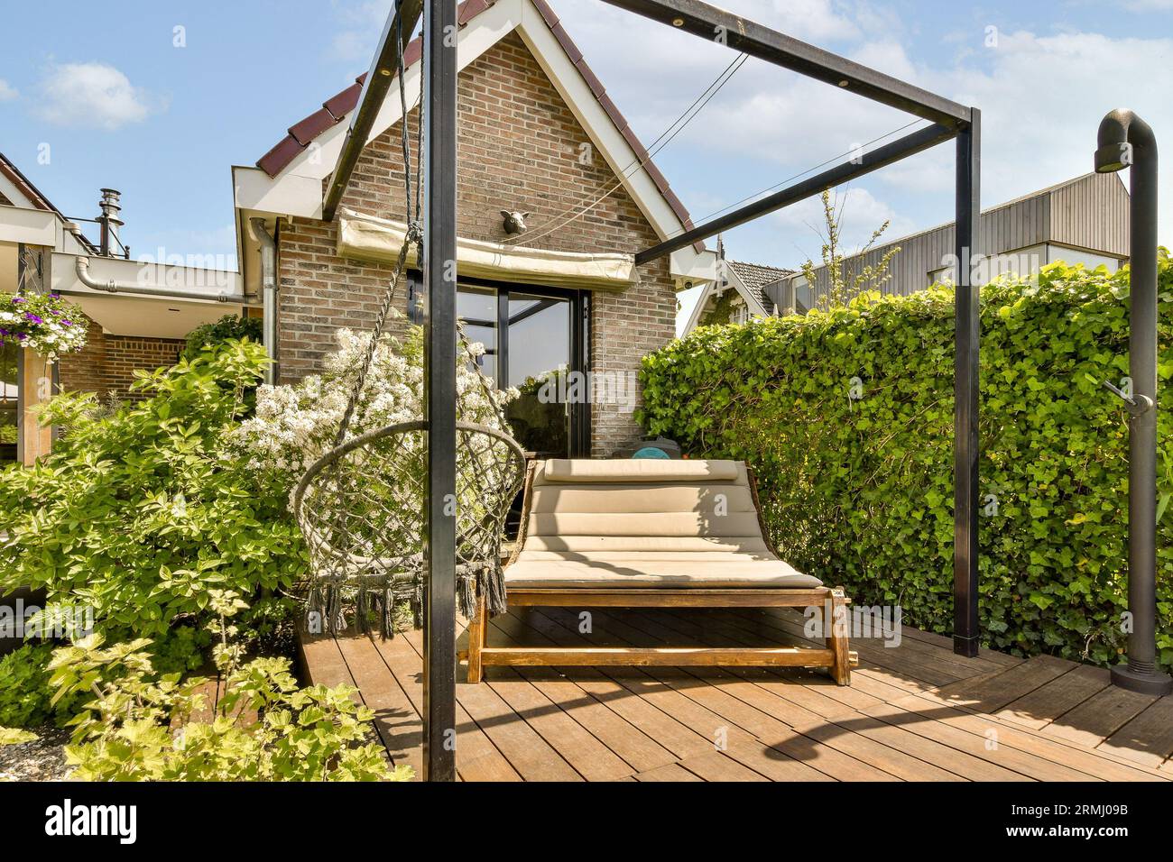 an outdoor living area with wooden decking and white flowers in the ...