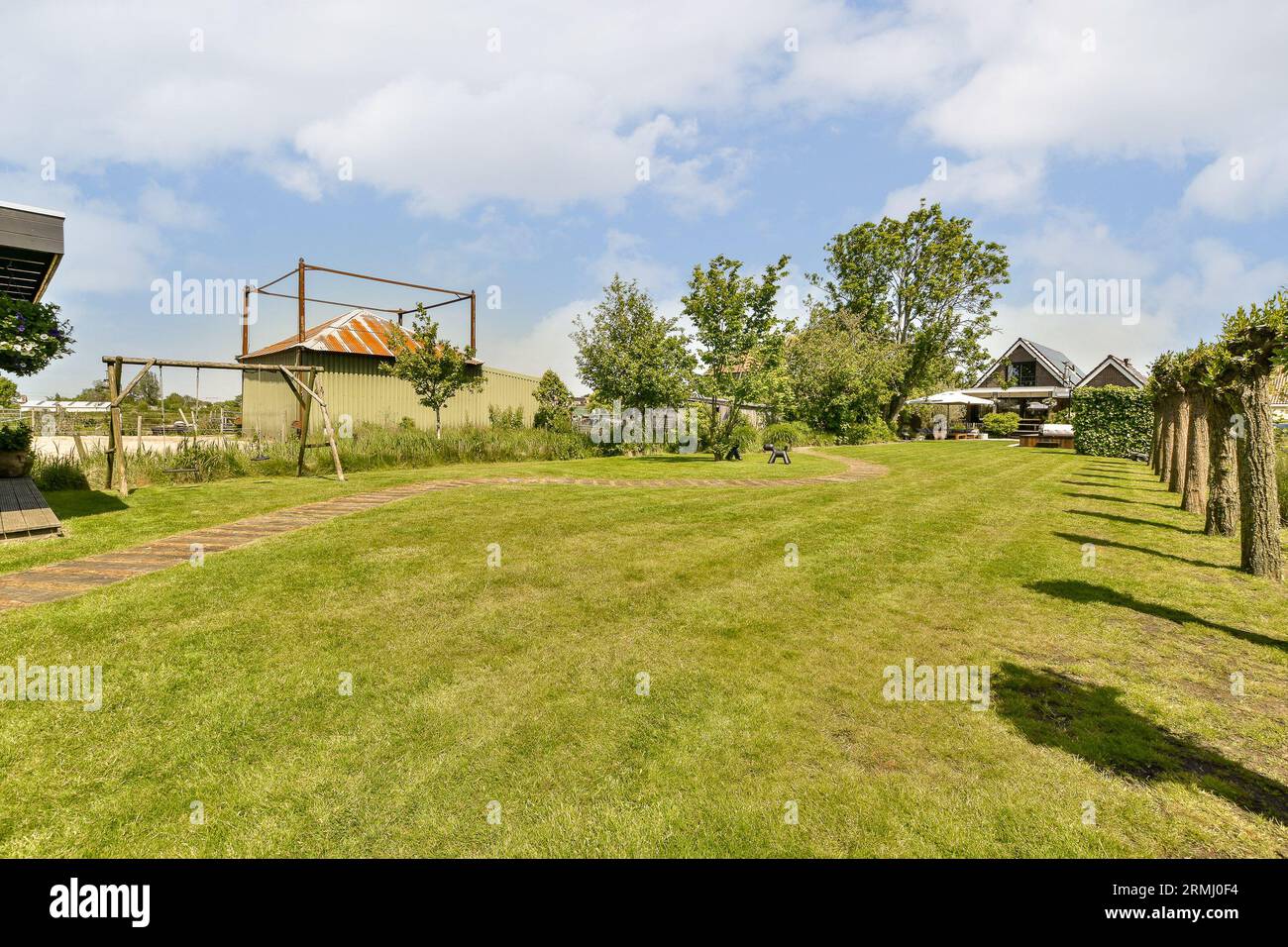 a grassy area with houses in the distance and trees on the other side ...