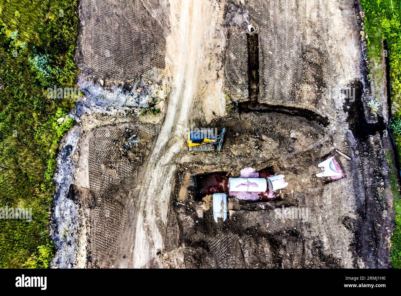 Dozer next to an open trench with two culverts ready for a connection ...