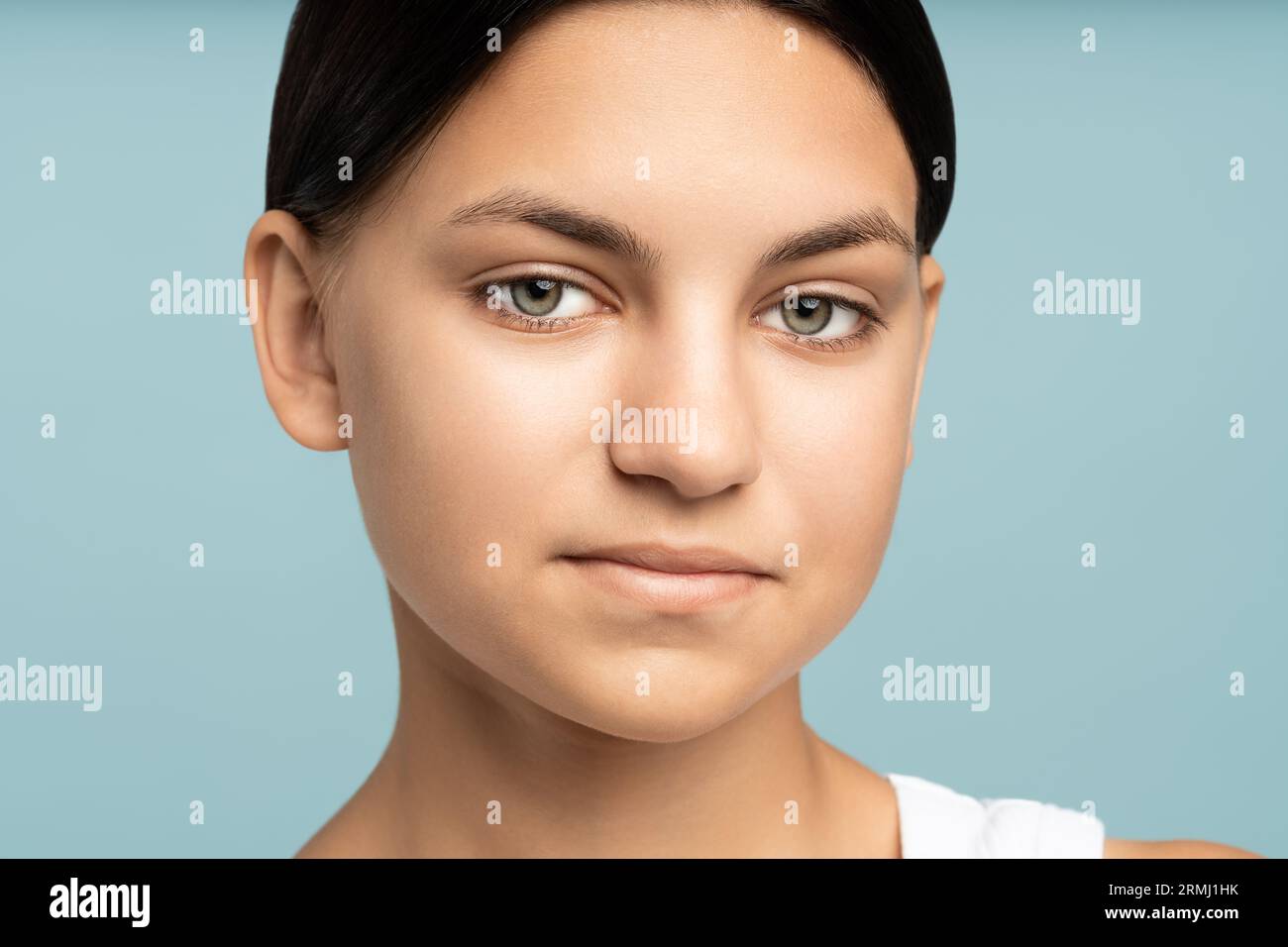 Teenage girl looking at camera, close up. Portrait of girl slight smile ...