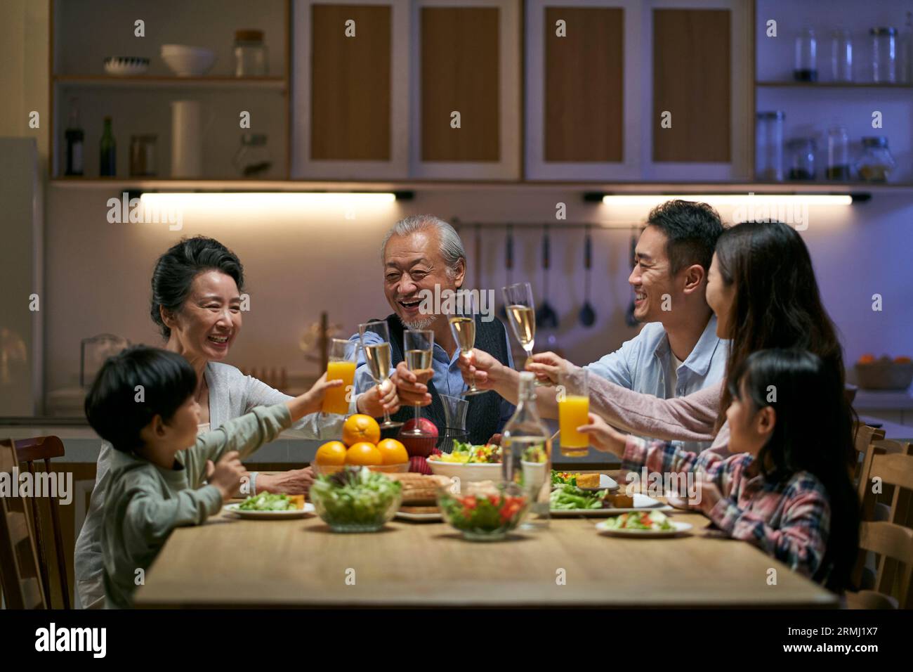 three generation asian family gathering at home celebrating holiday ...