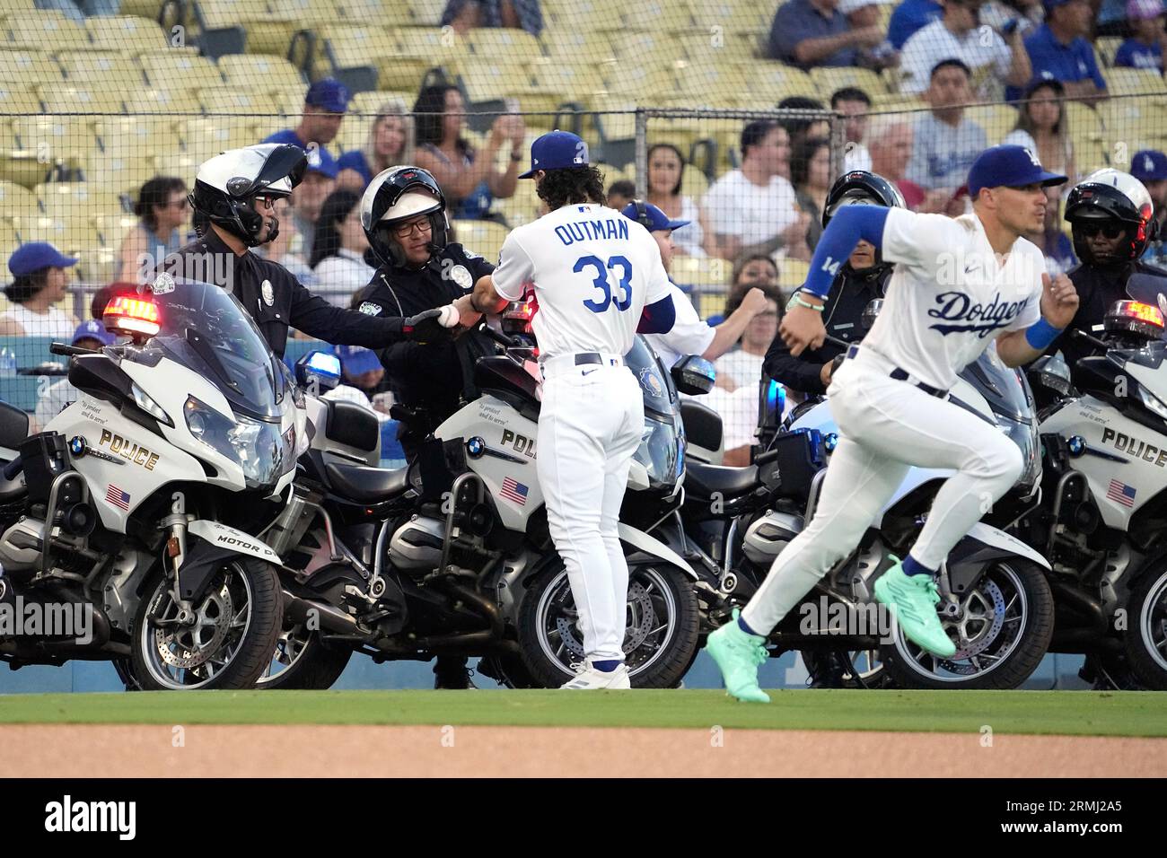 Los Angeles Dodgers' James Outman, center, signs autographs for Los ...