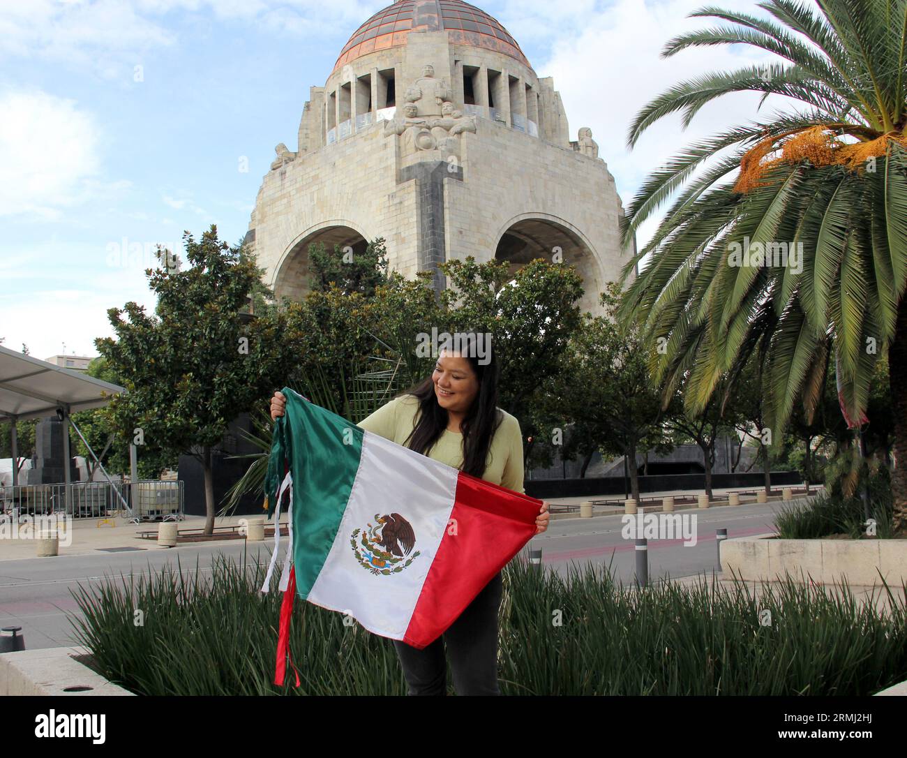 Mexican adult woman shows the flag of Mexico with pride of her culture ...
