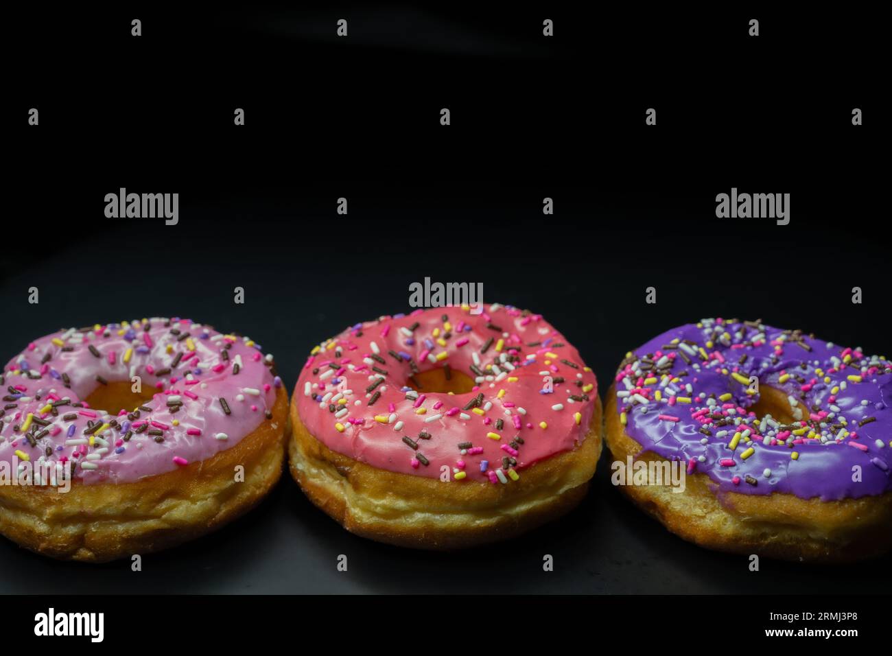 Trio of pastel doughnuts with sprinkles Stock Photo - Alamy