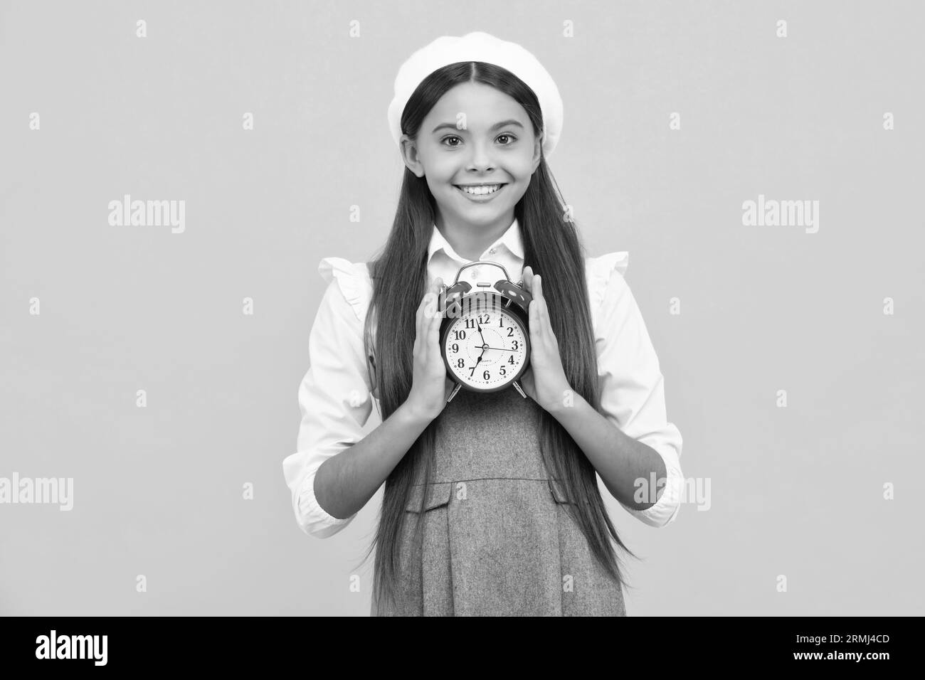 Punctual teen girl checking time. Child with alarm clock showing time ...