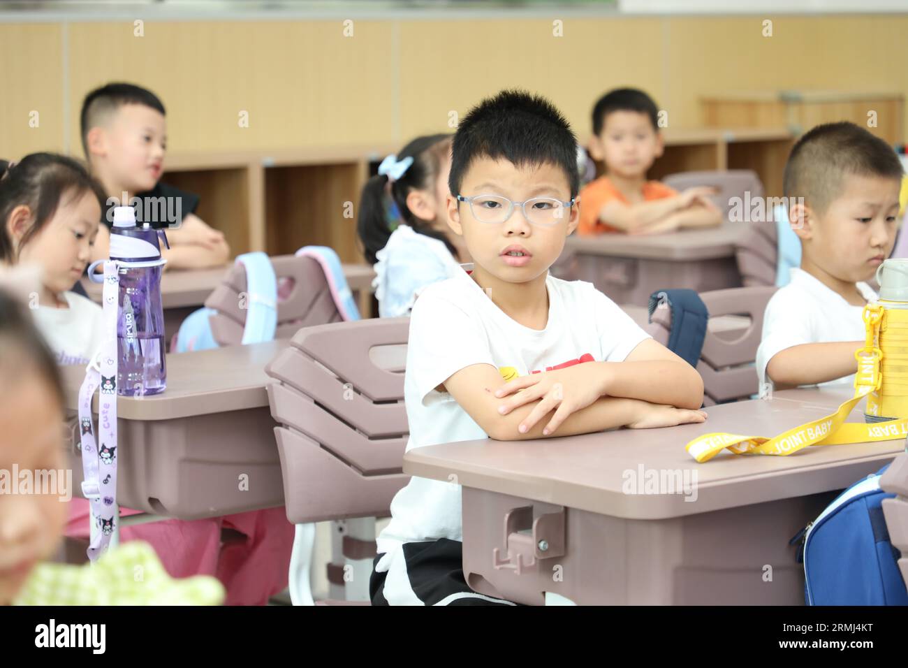 The primary school students of the first grade enter the campus in ...
