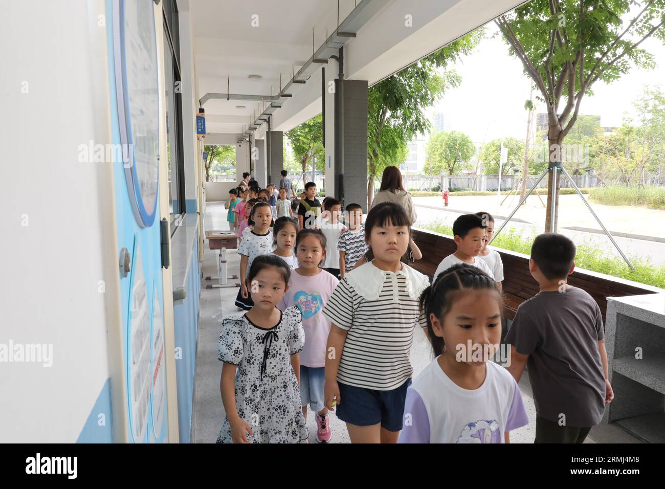 The primary school students of the first grade enter the campus in ...