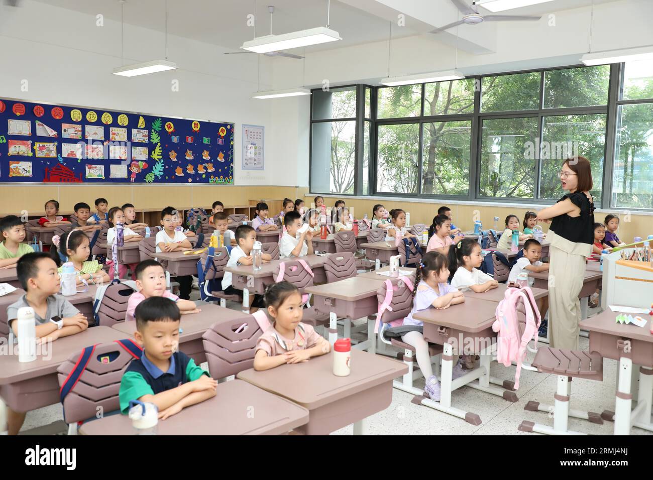 The primary school students of the first grade enter the campus in ...