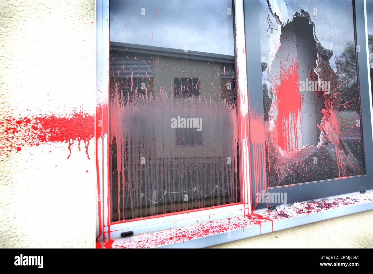 A window is smashed and red paint is sprayed inside the office at the ...