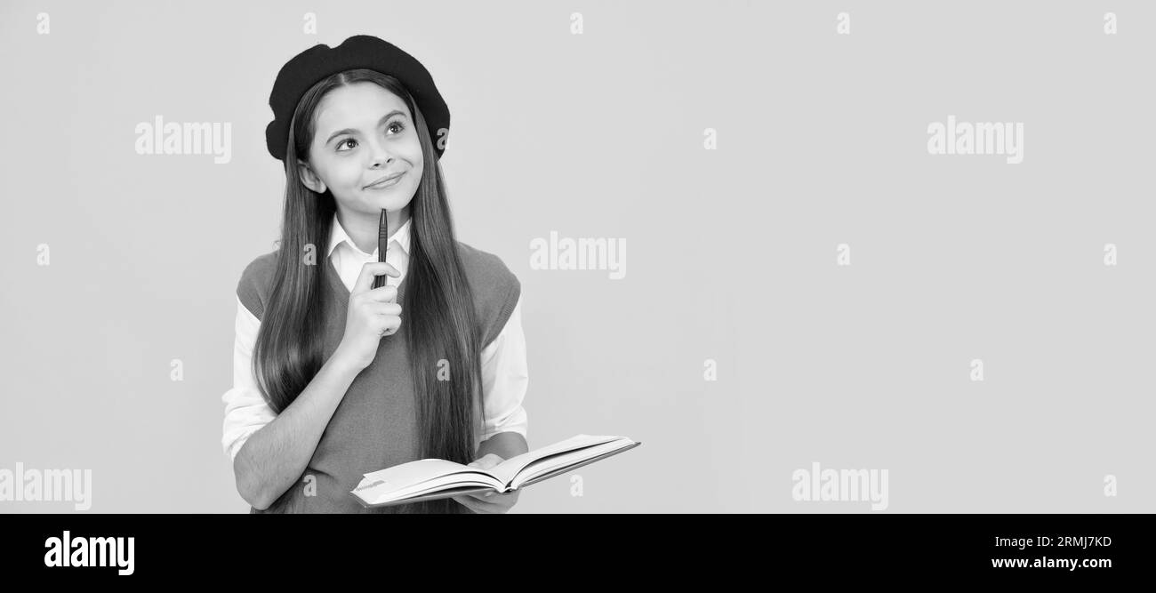 thinking teen school girl in french beret making notes in notepad ...
