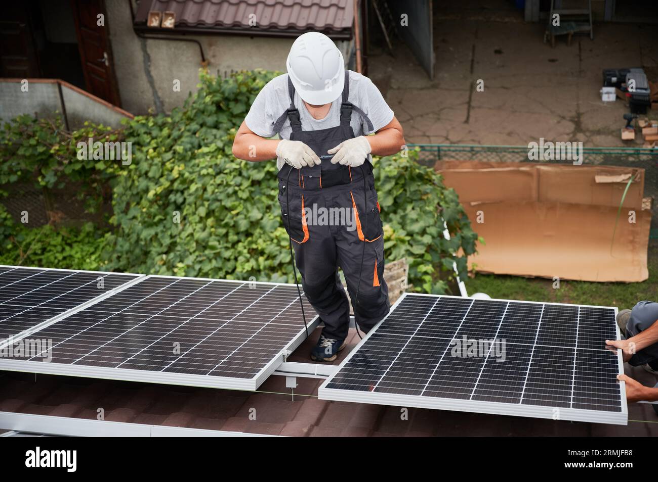 Men mounters installing photovoltaic solar moduls on roof of house ...
