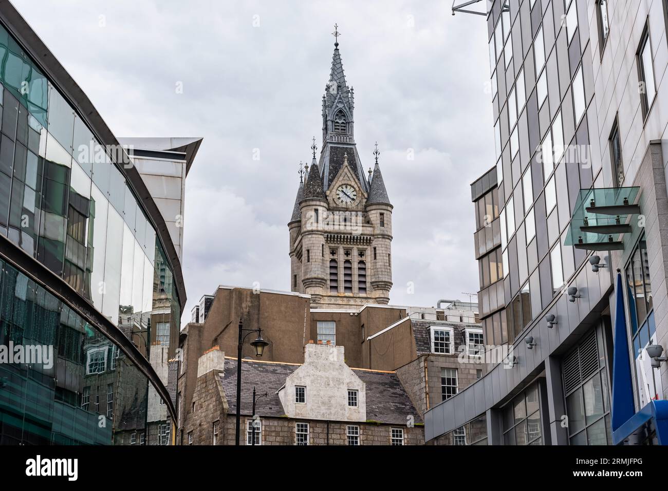 Antique granite tower jutting above modern glass buildings in Aberdeen ...